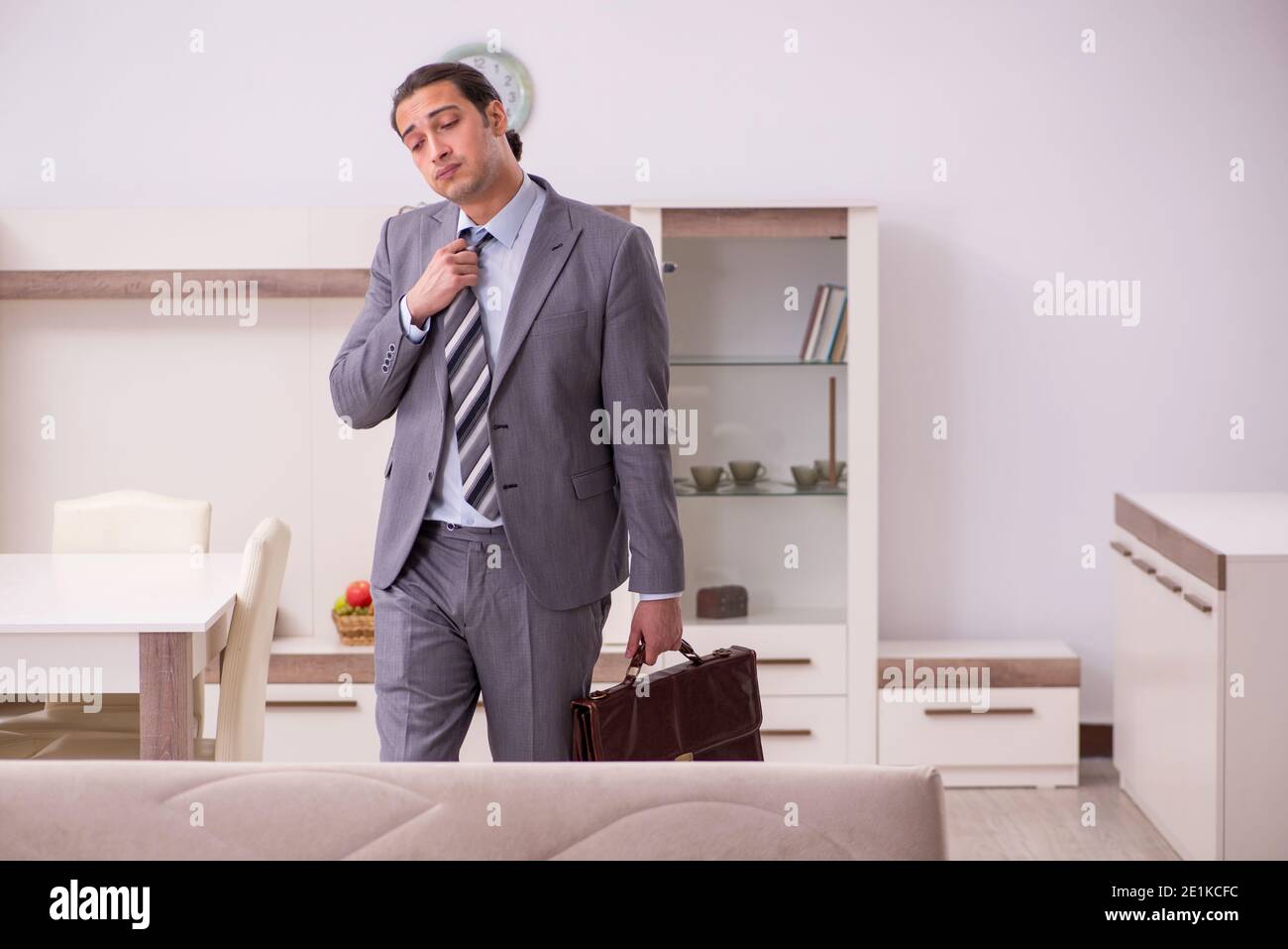 Tired businessman coming home after working day Stock Photo - Alamy