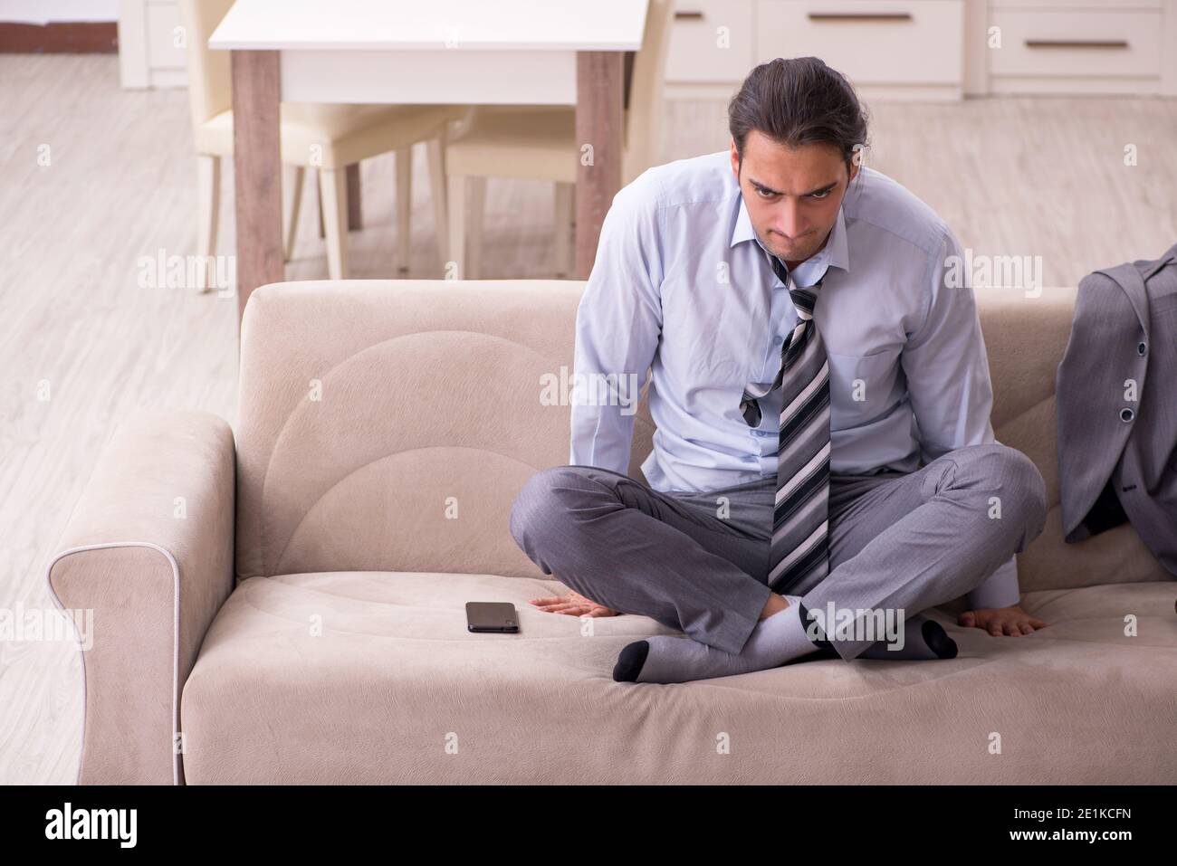 Tired businessman coming home after working day Stock Photo - Alamy