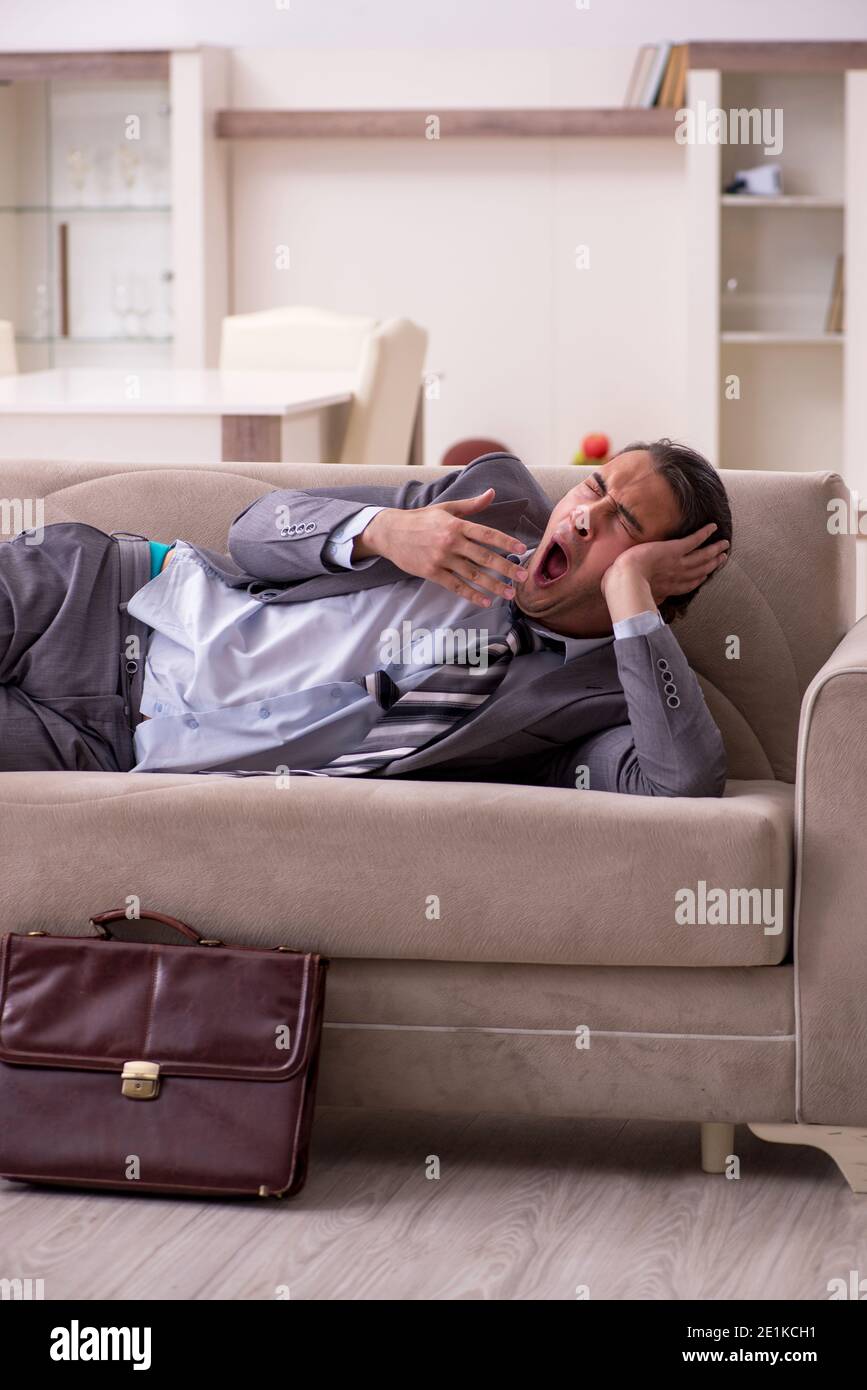 Tired businessman coming home after working day Stock Photo - Alamy