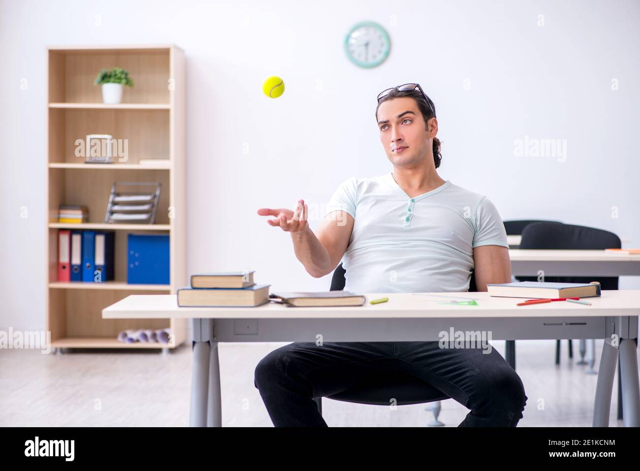 Male student throwing tennis ball during exam preparation in the ...