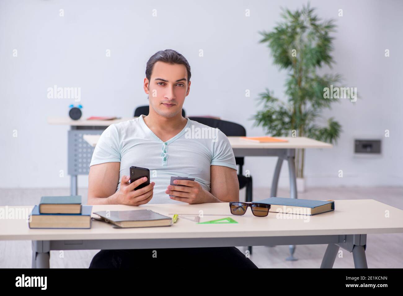 Male student playing cards during exam preparation in the classroom ...