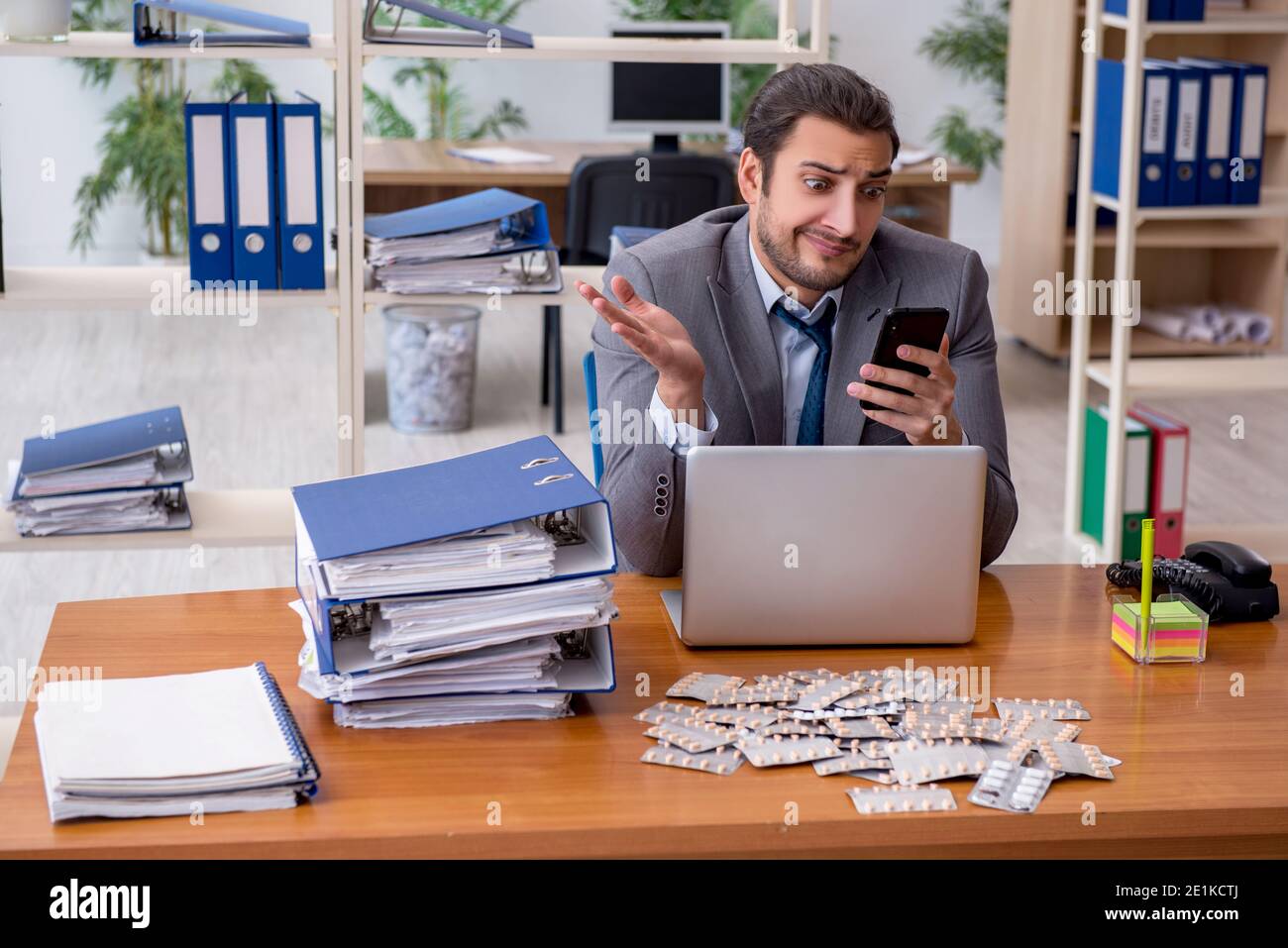 Male sick employee suffering at workplace Stock Photo - Alamy