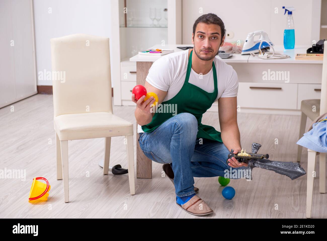 Young contractor cleaning the flat after kids' party Stock Photo - Alamy