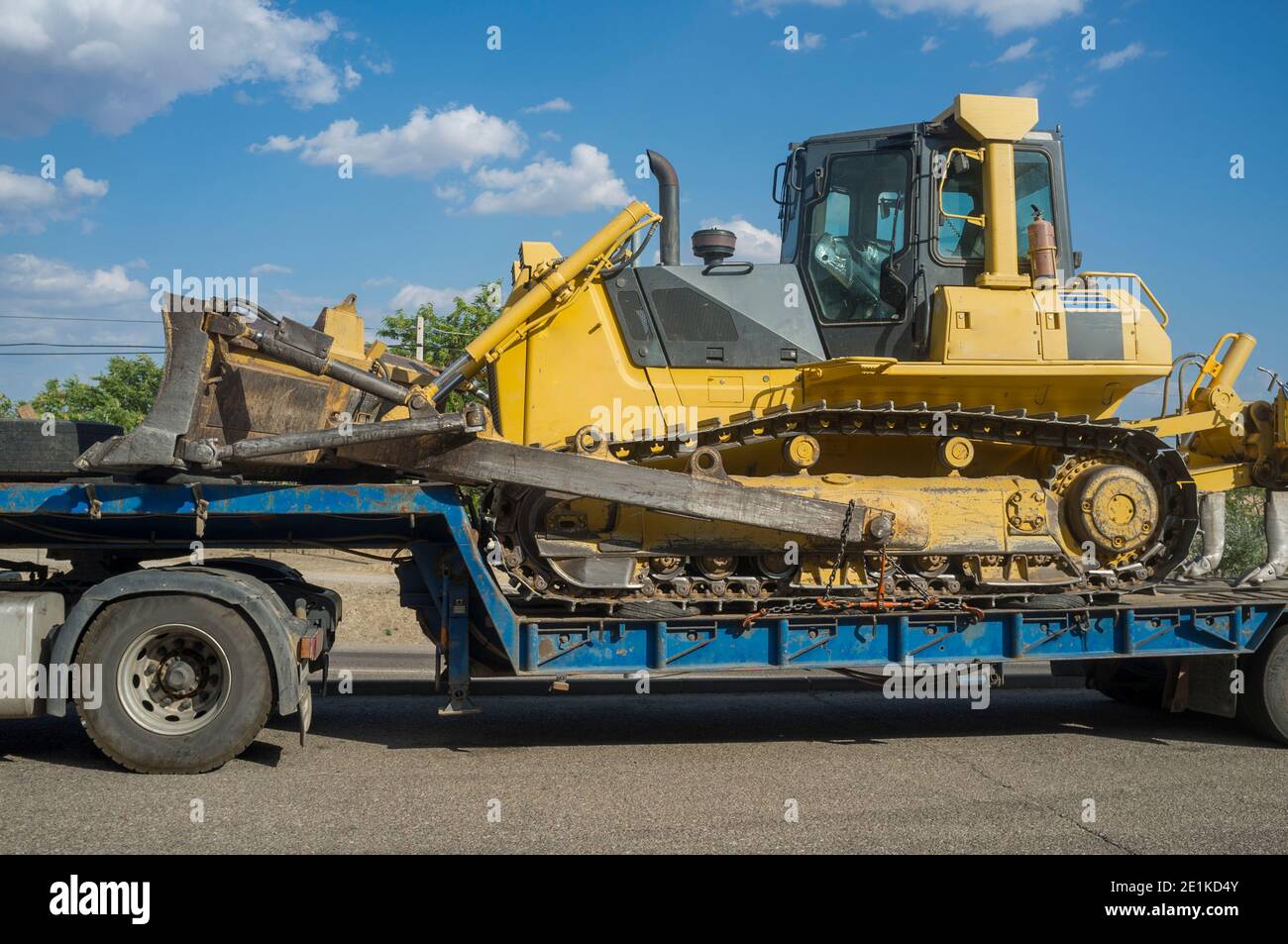 Heavy-duty truck carrying bulldozer equipped with multishank ripper ...