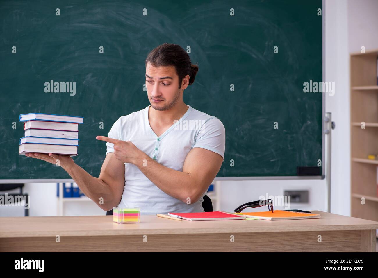 Young teacher student sitting in the classroom Stock Photo - Alamy