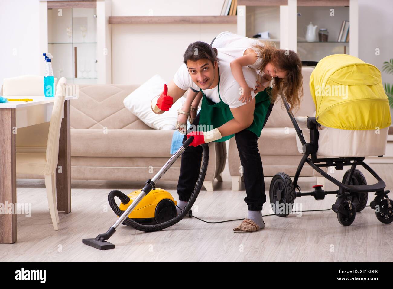 Young contractor cleaning the house with his small daughter Stock Photo ...