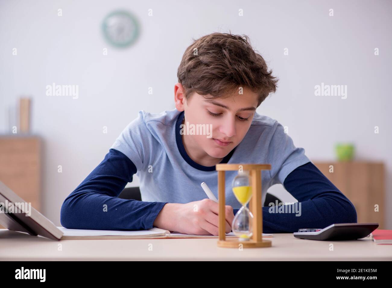 Boy preparing for exams in time management concept Stock Photo - Alamy