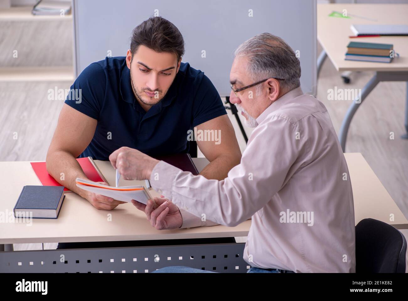 Old teacher and young student in the classroom Stock Photo - Alamy
