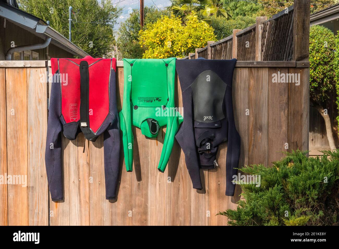 Wetsuits hanging to dry Stock Photo - Alamy