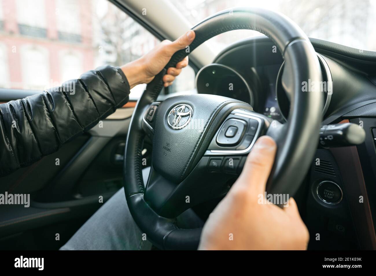 Man driving Toyota car. Close up of steering wheel with driver hands ...