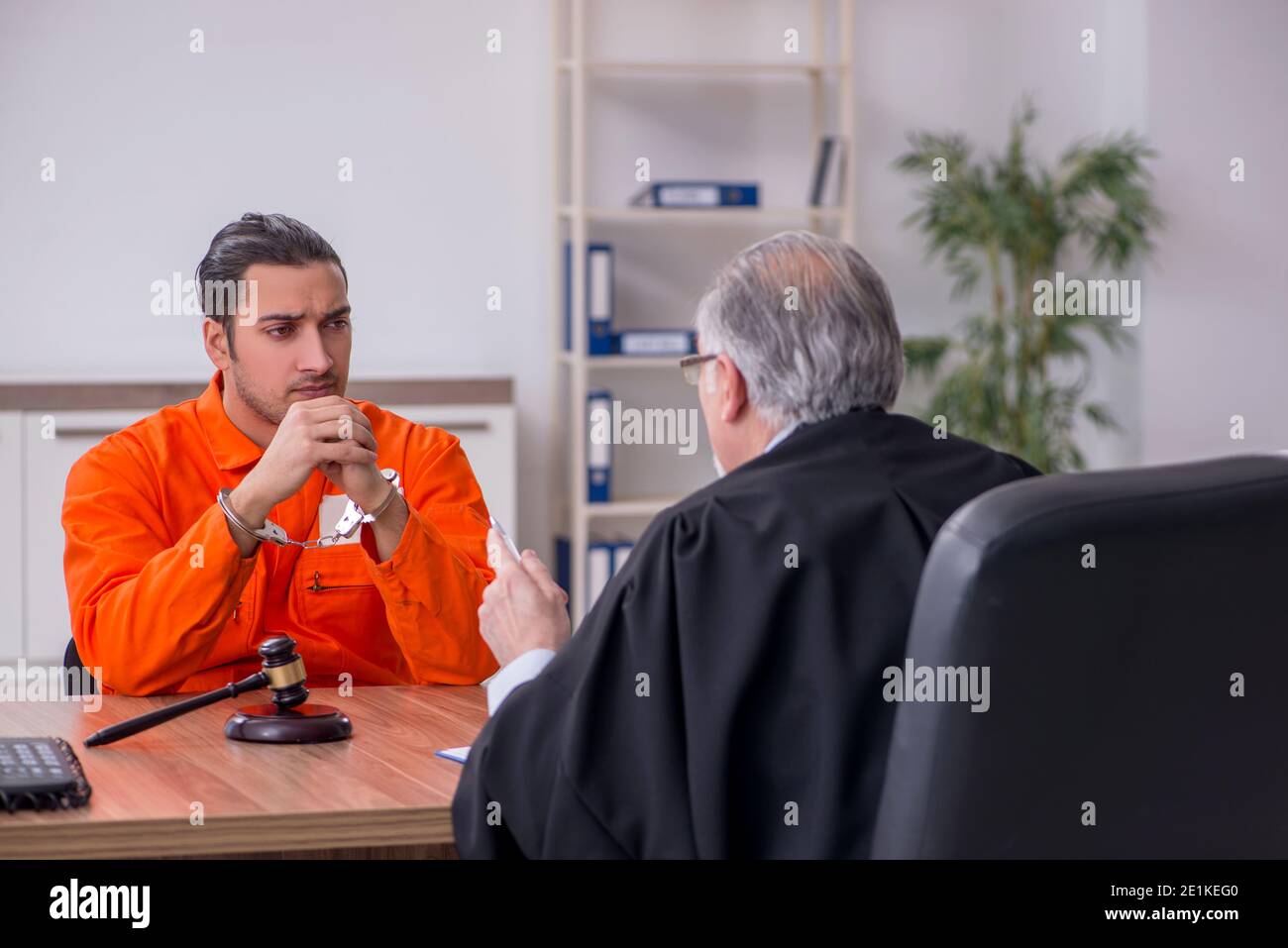 Old judge meeting with young captive in courthouse Stock Photo - Alamy