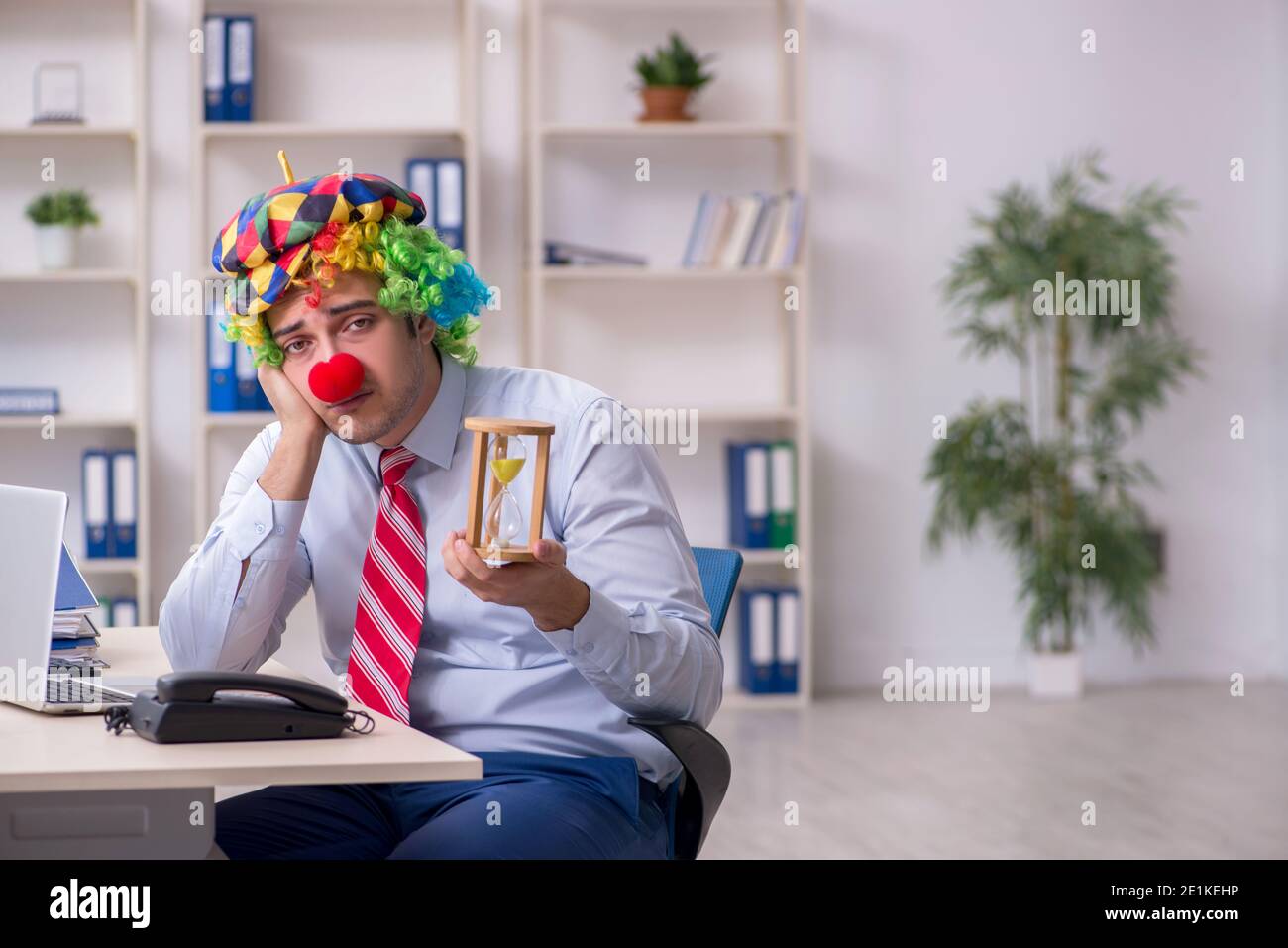 Funny employee clown working in the office room Stock Photo - Alamy