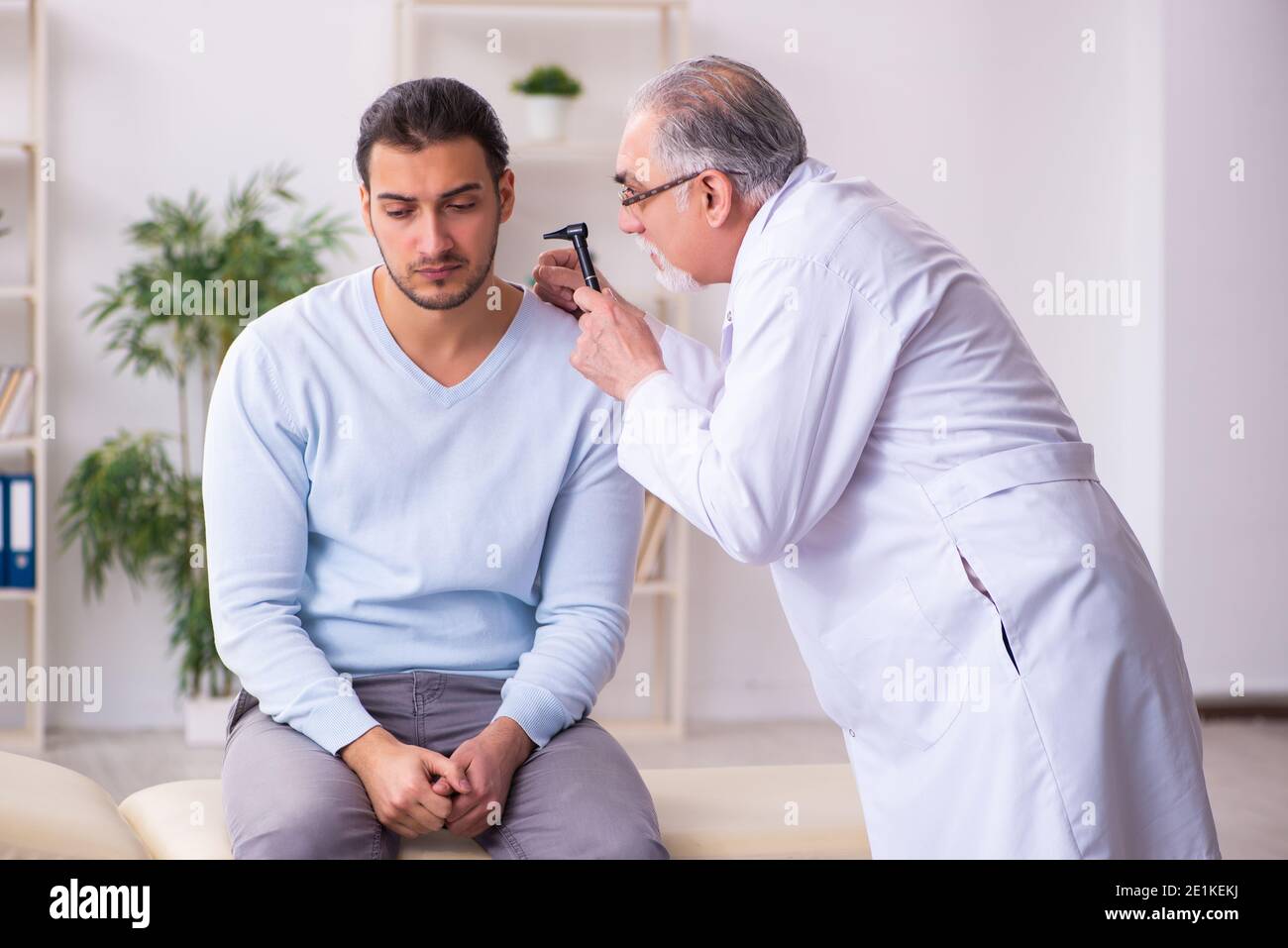 Sick man visiting old doctor otolaryngologist Stock Photo - Alamy
