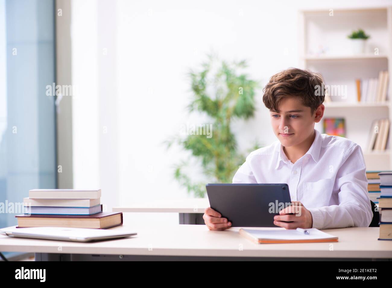 Schoolboy in teleeducation concept in the classroom Stock Photo - Alamy