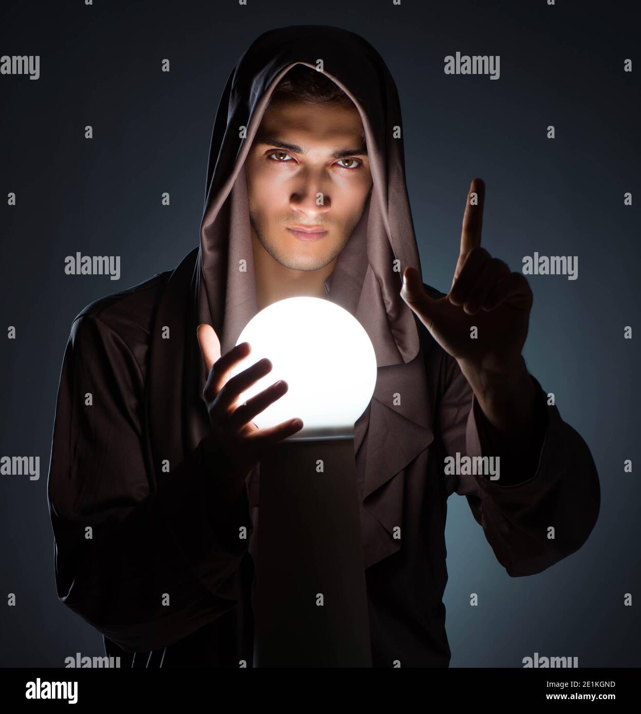 The young wizard with crystal ball in dark room Stock Photo - Alamy