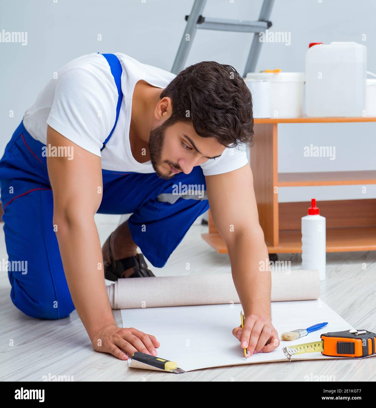 Repairman doing renovation repair in the house with paper wallpaper ...