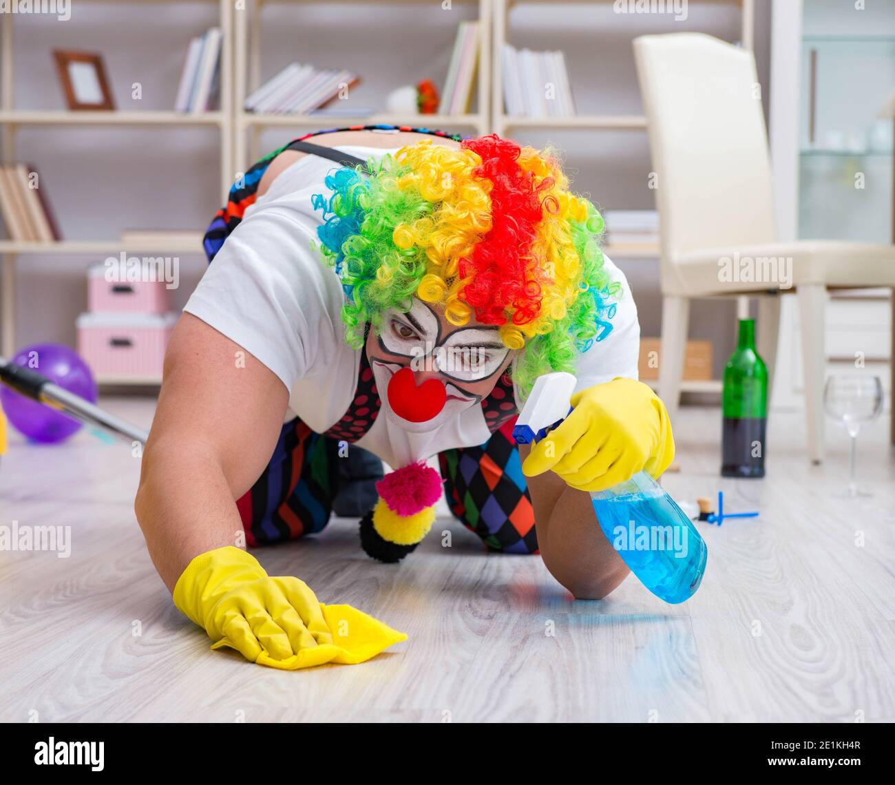 The funny clown doing cleaning at home Stock Photo - Alamy