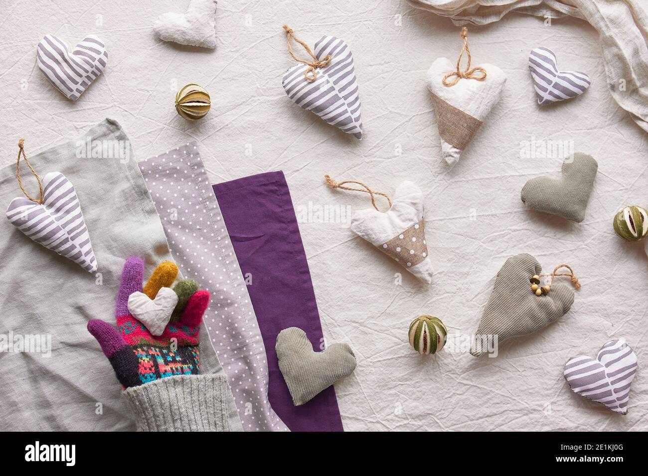 Hand made textile hearts and balls on cotton background. Hand holds ...