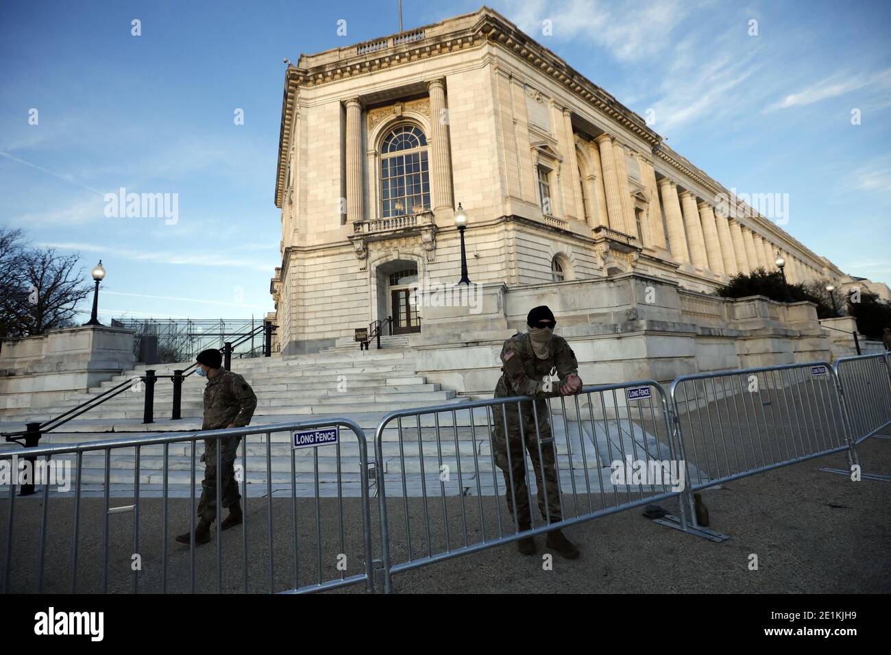 U.S. National Guard members stand behind a temporary fence placed ...