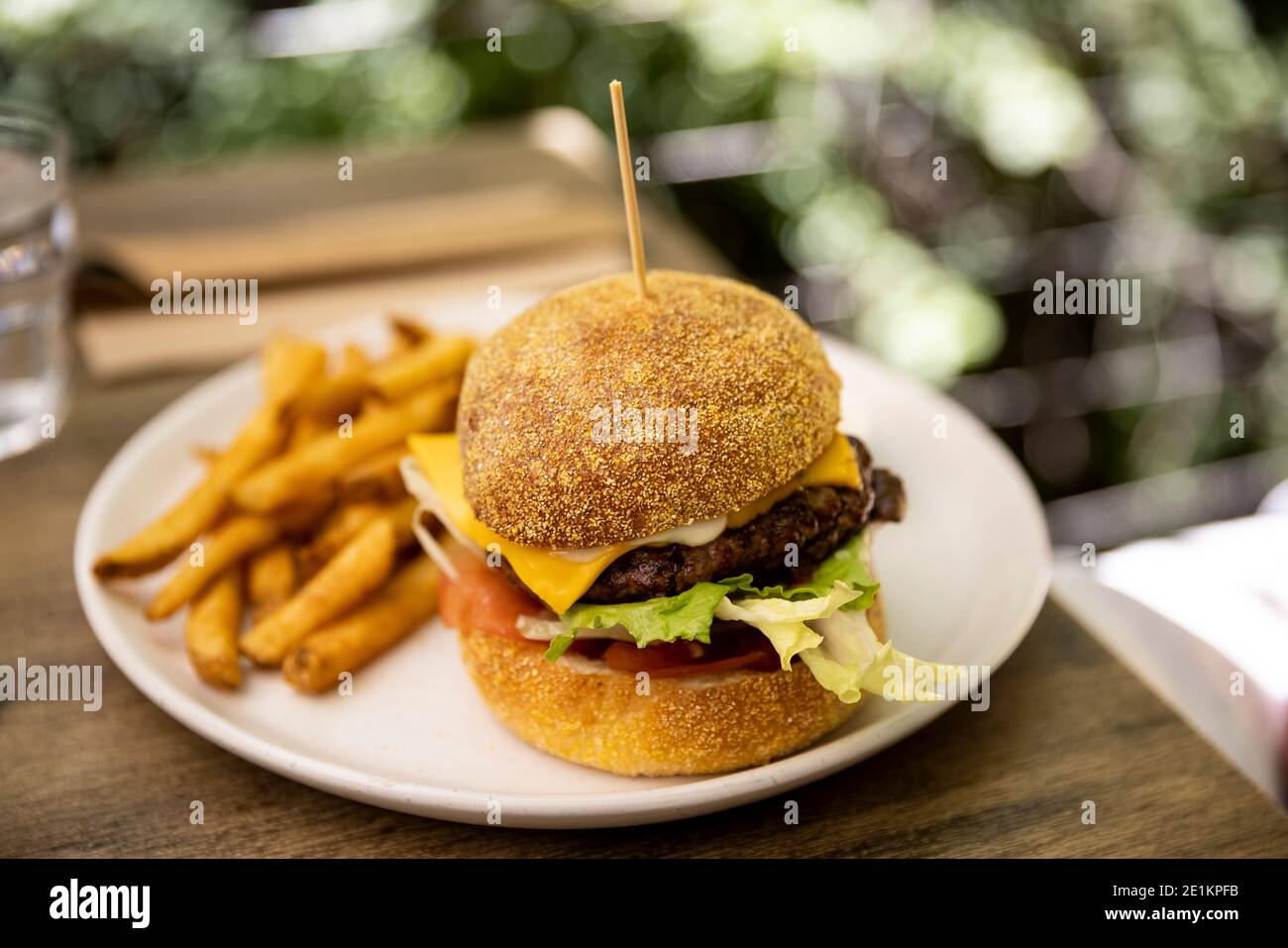 A delicious cheeseburger and fries served on an outside table Stock ...