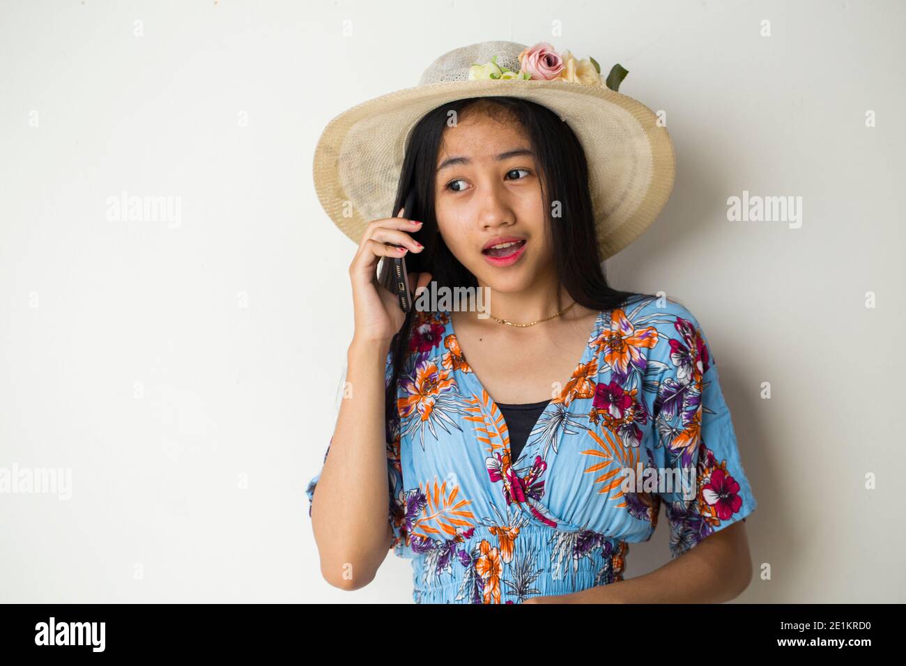 Asian woman tourist speaking on the phone isolated on white background ...