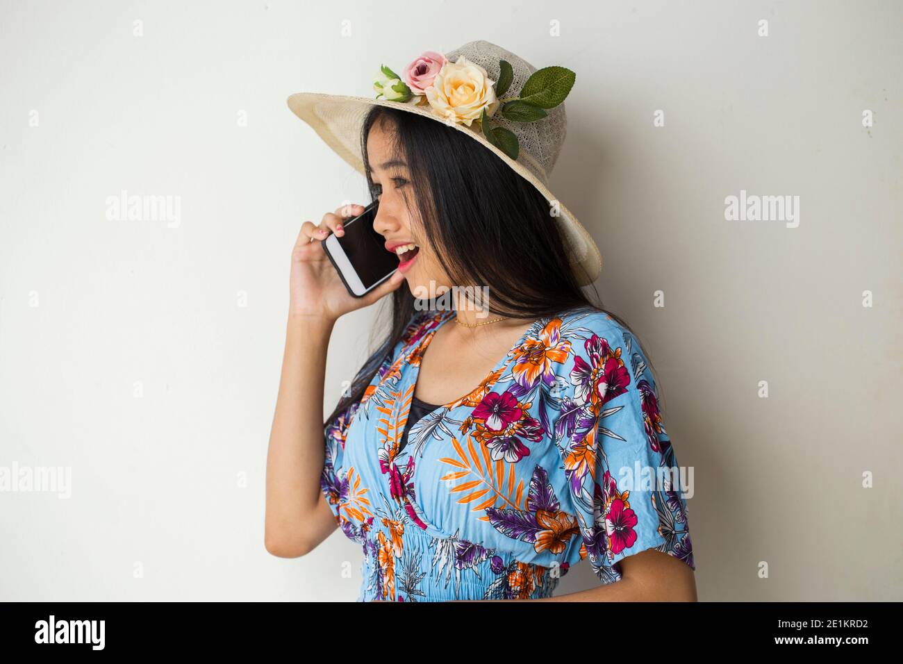 Asian woman tourist speaking on the phone isolated on white background ...
