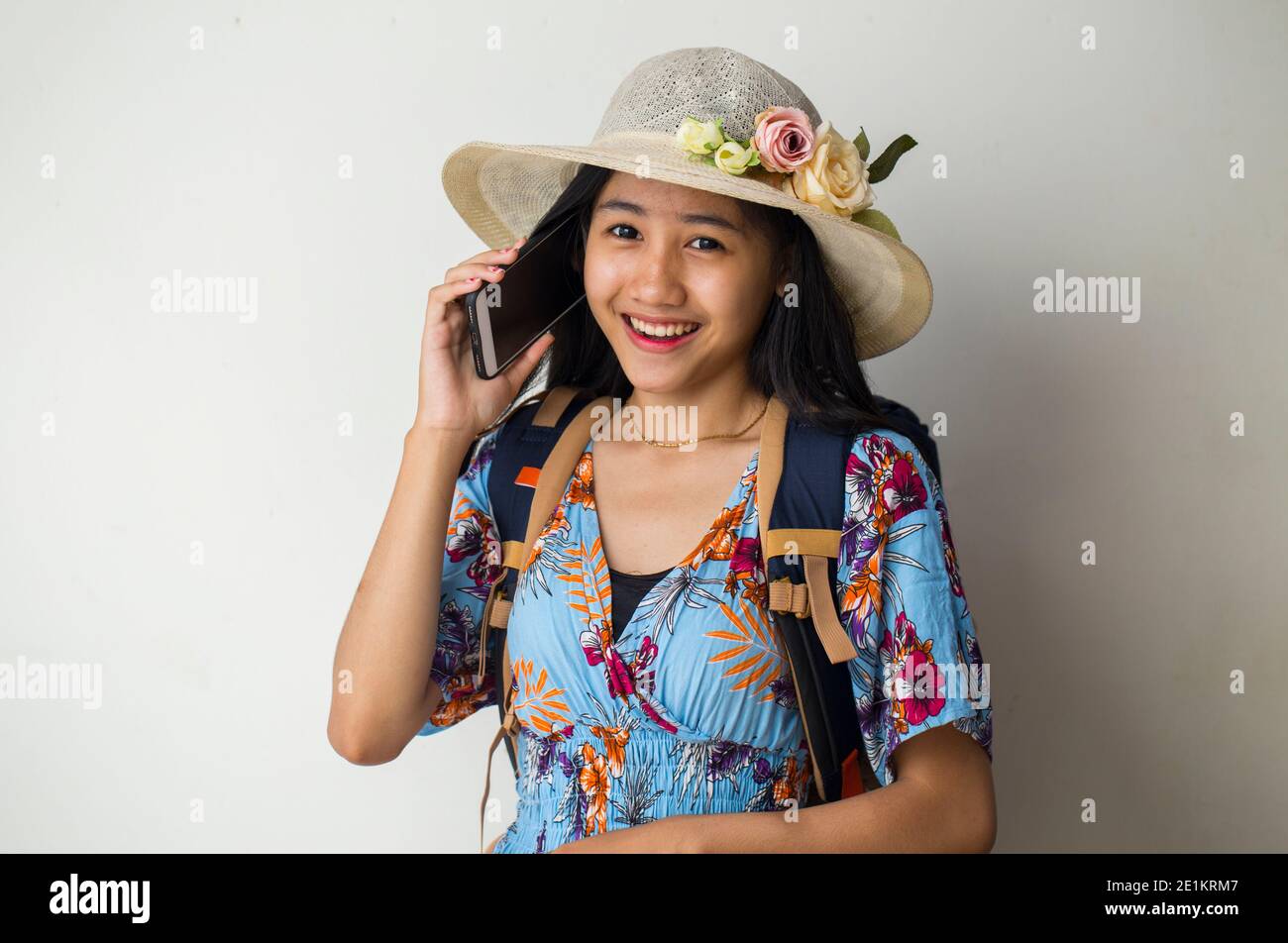 Asian woman tourist speaking on the phone isolated on white background ...