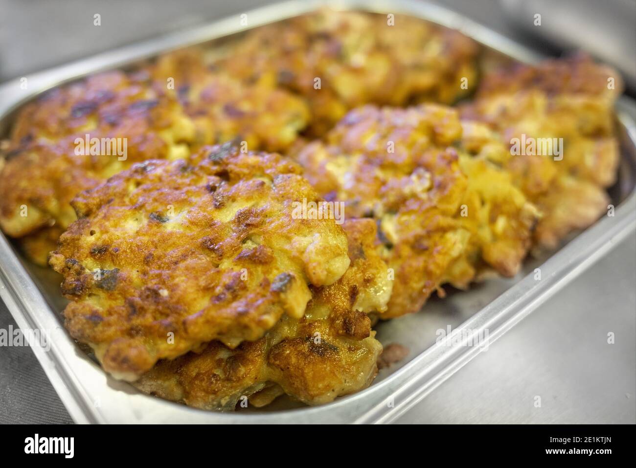 Fried chicken chops in batter are laid out for serving. Close-up of ...