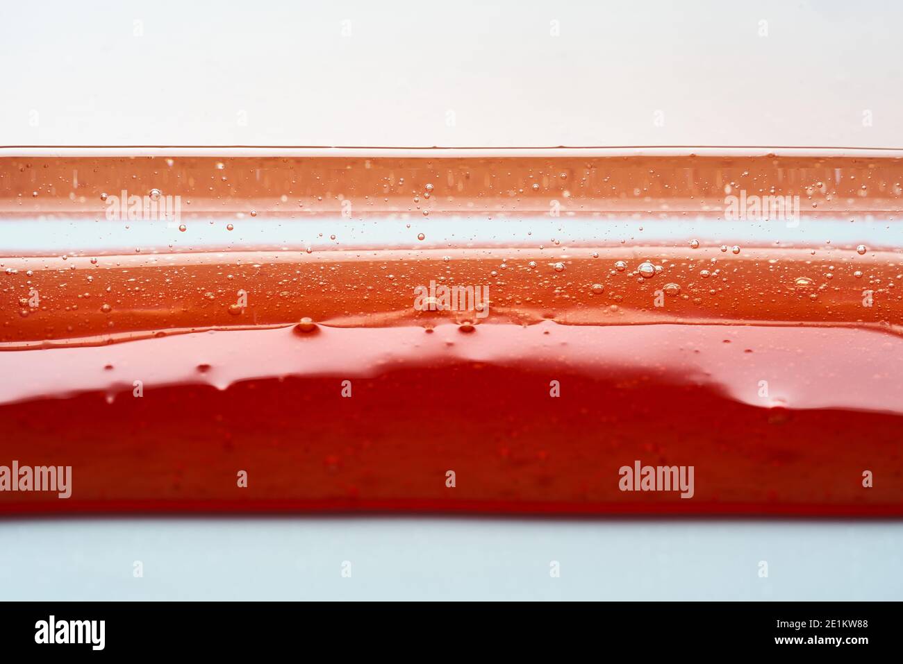 The texture of the red transparent cosmetic gel. Abstract background ...