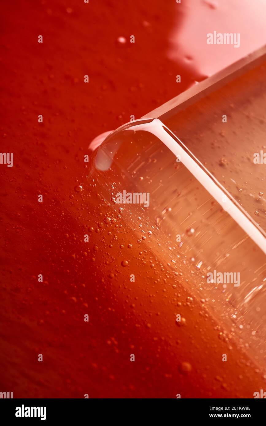 The texture of the red transparent cosmetic gel. Abstract background ...
