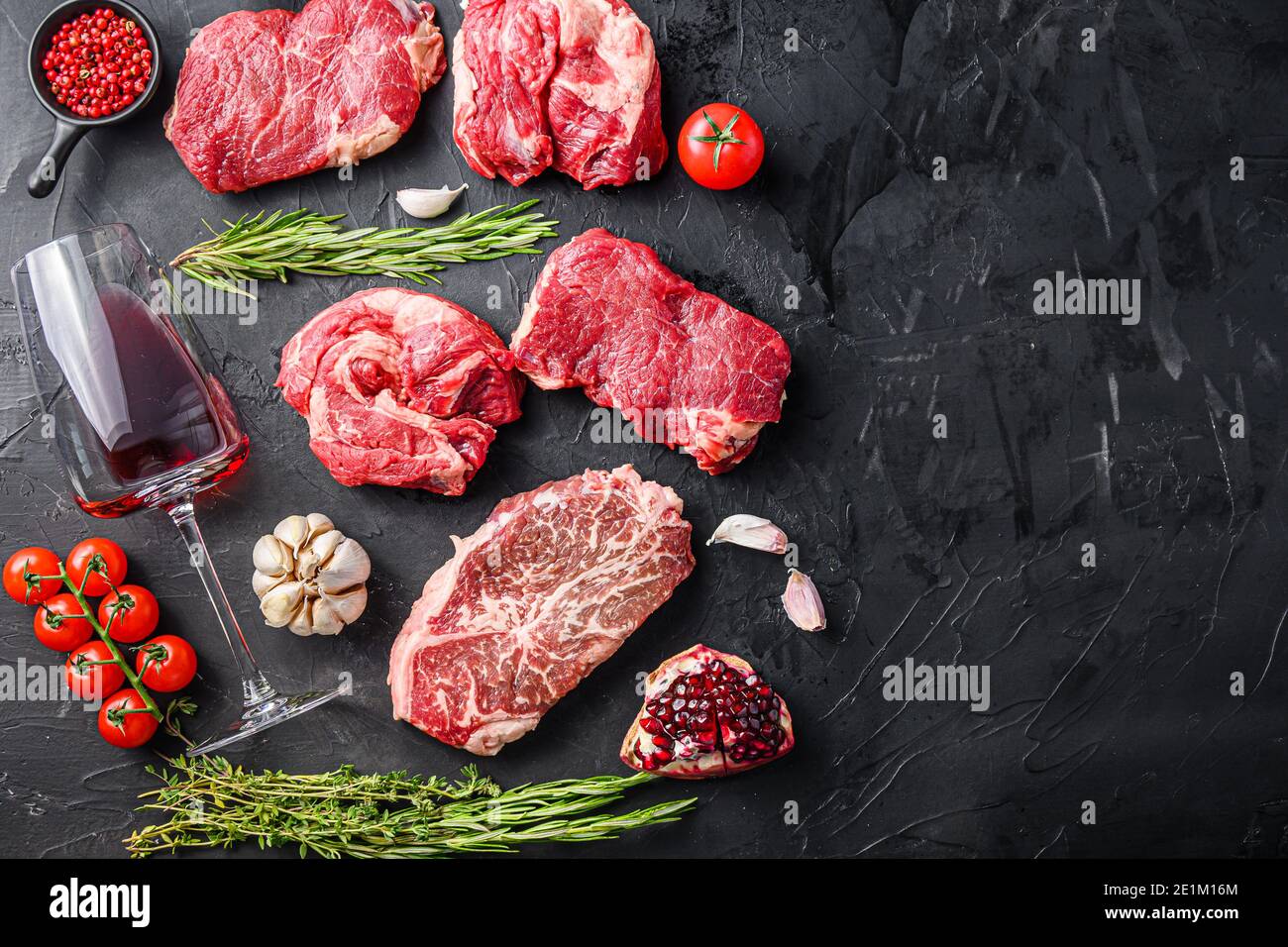 Alternative beef cut set with herbs and red wine glass, top view with ...