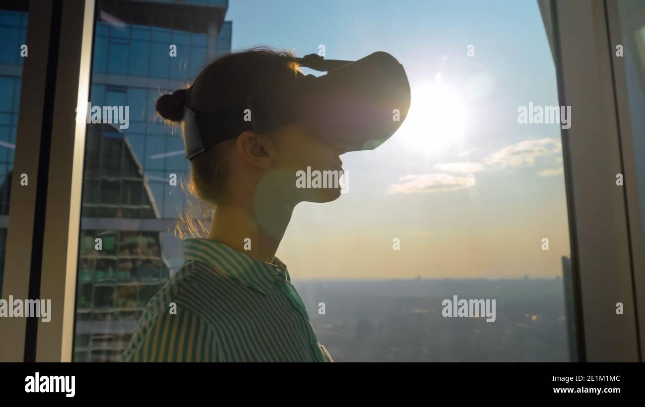 VR concept - young woman using virtual reality headset against ...