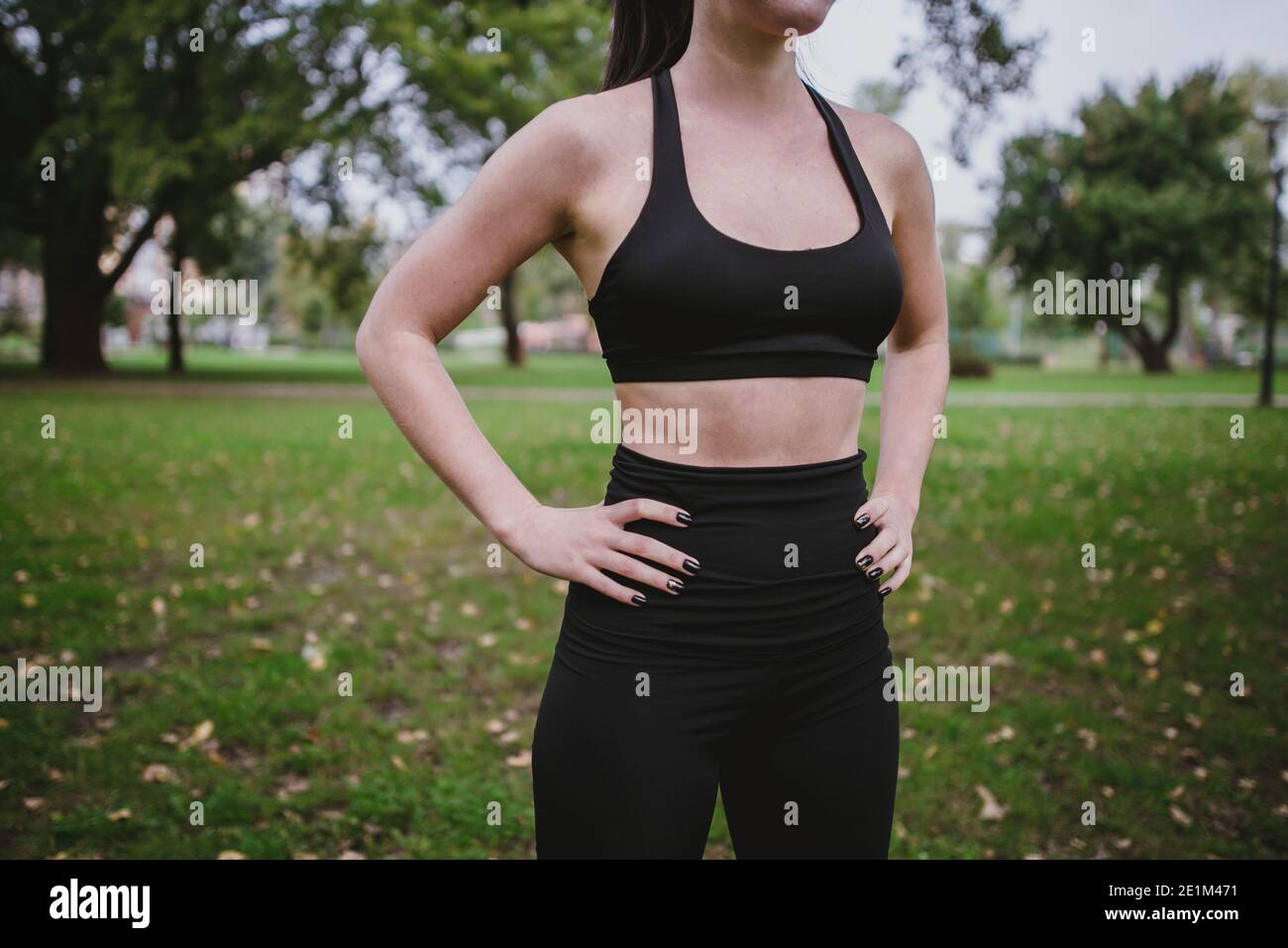 Young woman core sport suit do the workout plays sports in the park ...