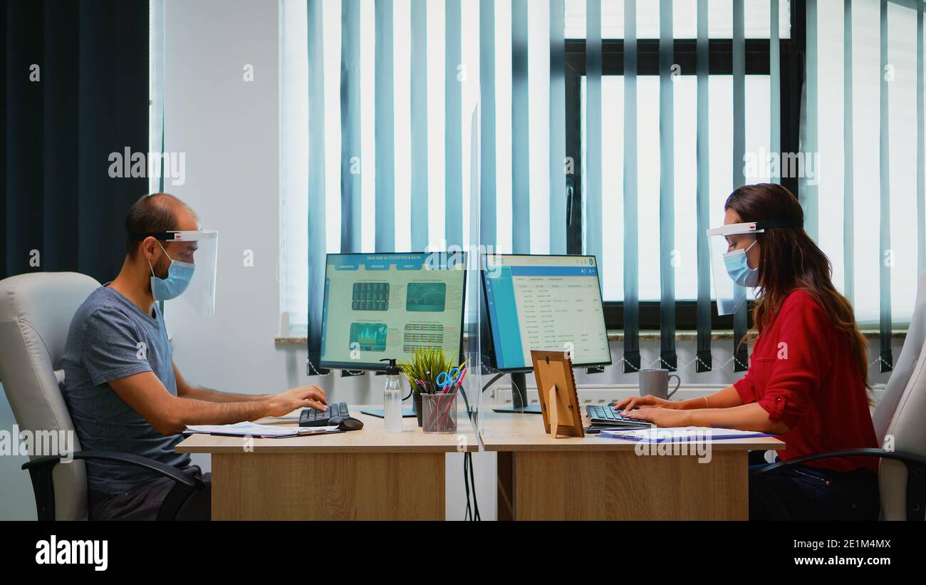 People with mask and visor working in new normal office checking ...