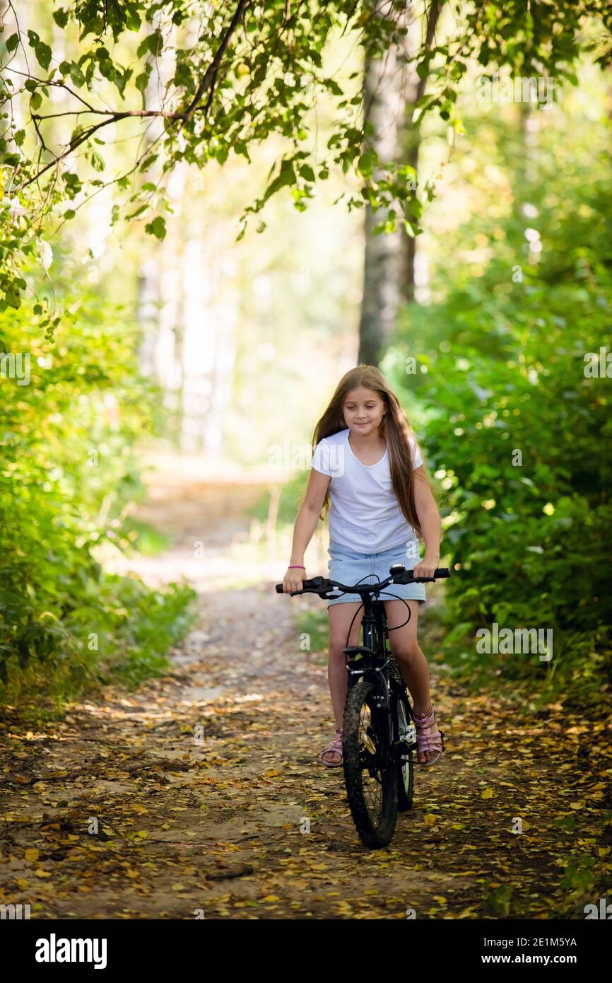 Children girl riding bicycle outdoor in forest smiling Stock Photo - Alamy