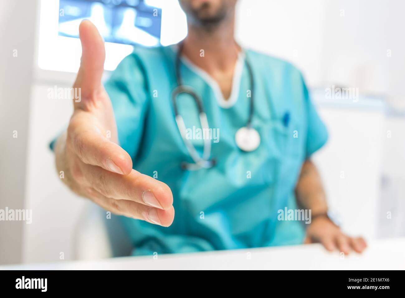 Young doctor man smiling reaches out to his patient, close up hand ...