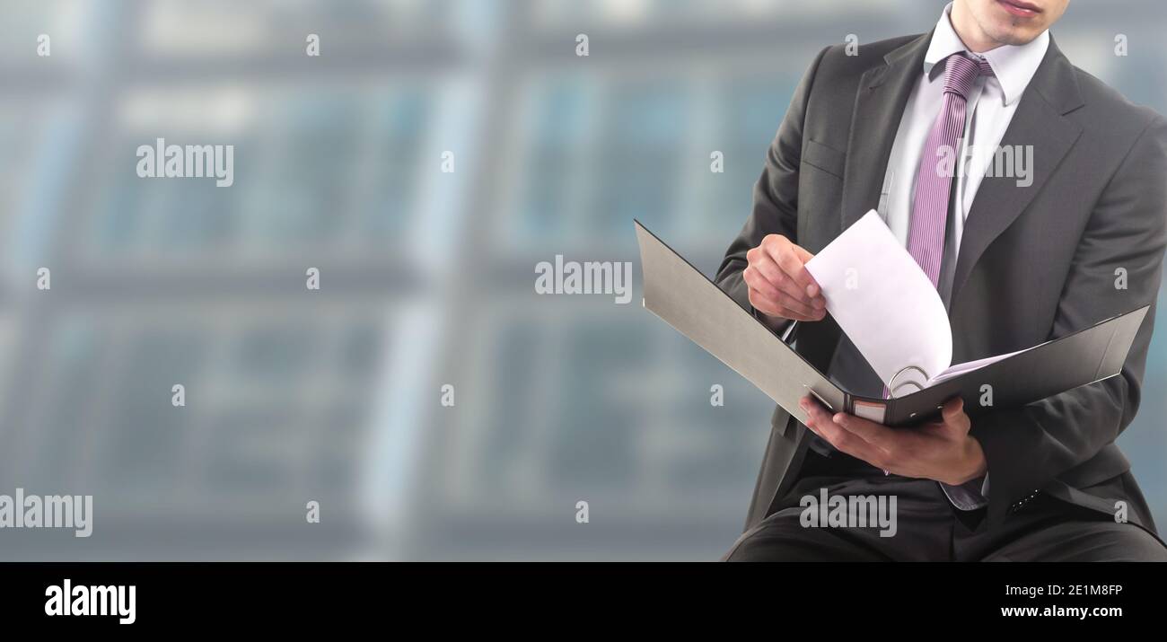 Business man working alone on laptop or with files, in background ...