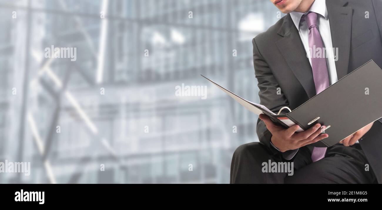 Business man working alone on laptop or with files, in background ...