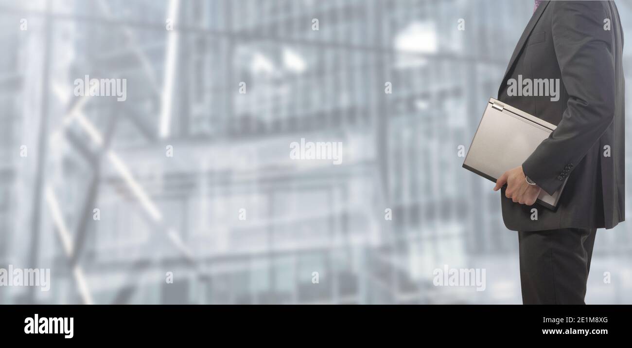 Business man working alone on laptop or with files, in background ...