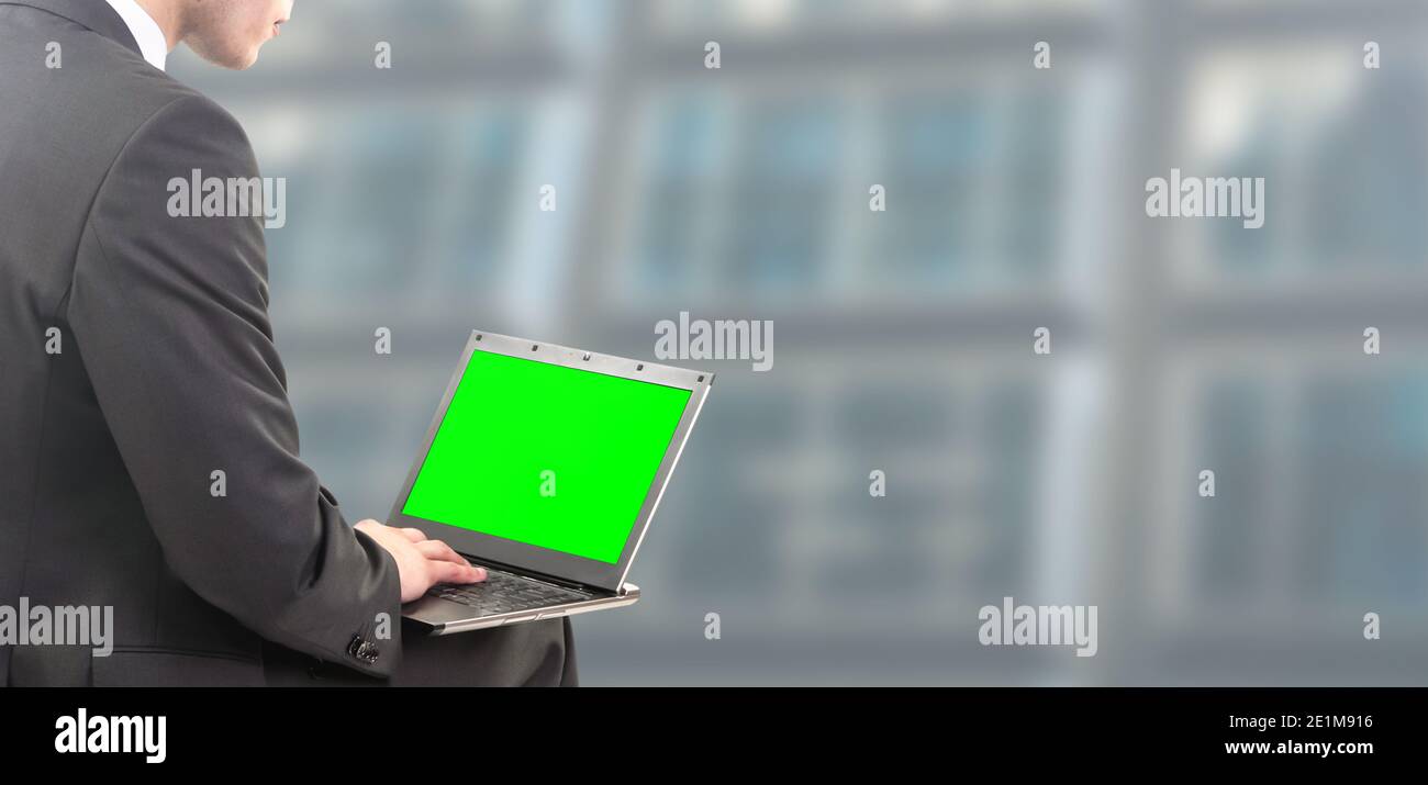 Business man working alone on laptop or with files, in background ...