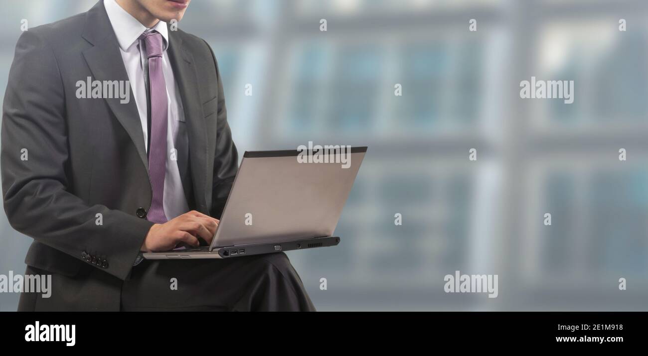 Business man working alone on laptop or with files, in background ...