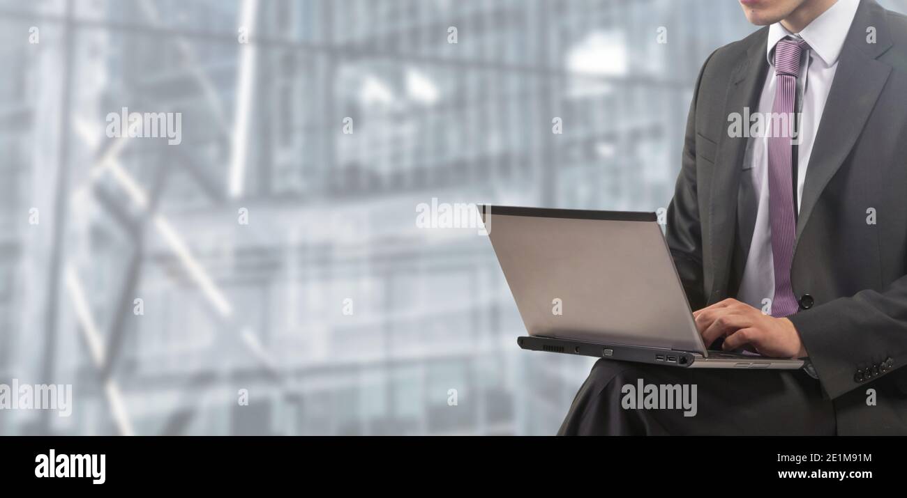 Business man working alone on laptop or with files, in background ...