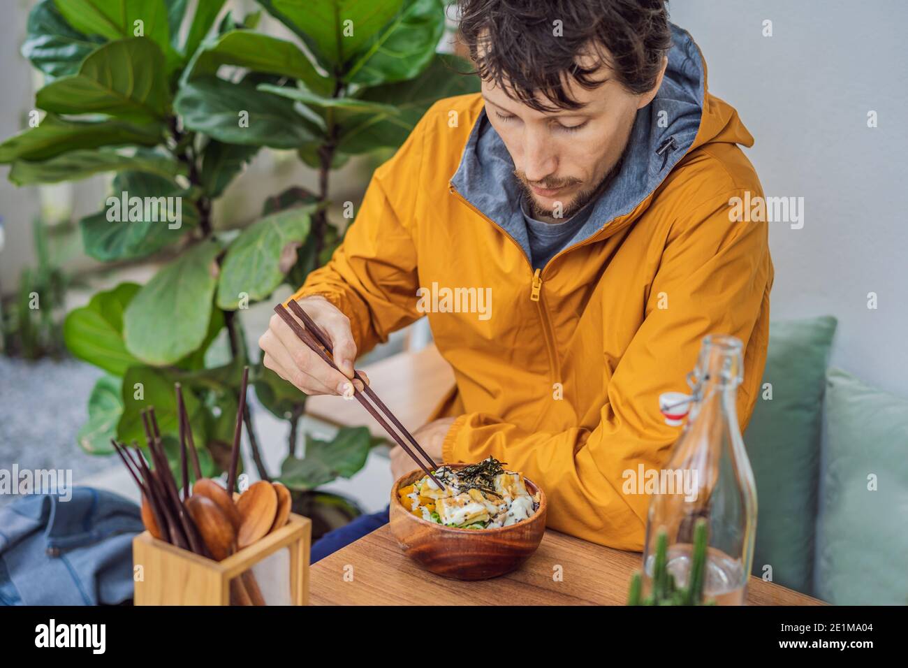Man Eating Raw Organic Poke Bowl With Rice And Veggies Close Up On The