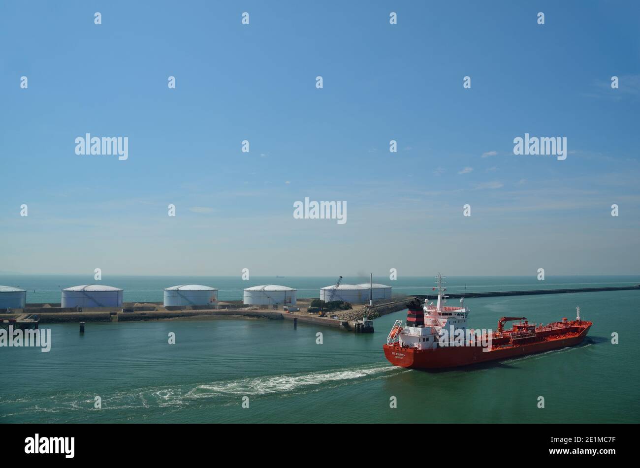 big red cargo ship in a harbor near the sea Stock Photo - Alamy