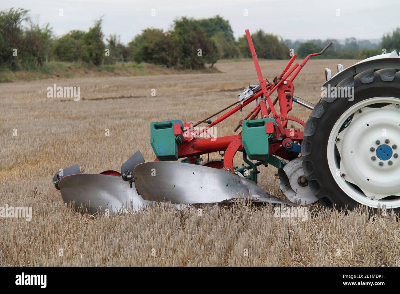 A Vintage Farming Plough Pulled by an Old Tractor Stock Photo - Alamy