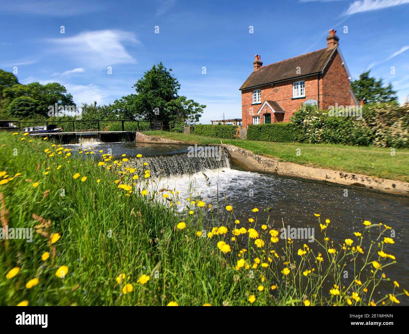 Lock keepers cottage by canal with small water fall blue sky Stock ...