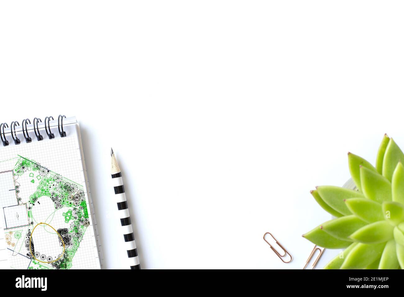 Notepad with spiral, pensil, clippers and home plant in soft focus on ...