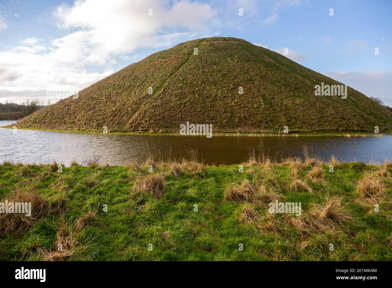 Water filled moat surrounding neolithic prehistoric mound of Silbury ...
