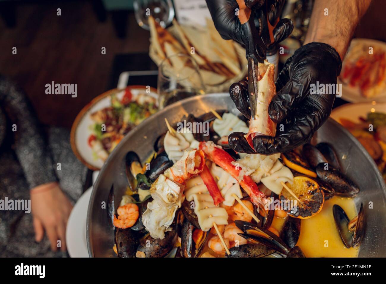 Hand of chef cleaning and preparing fresh raw Giant Mud Crab, serrated ...