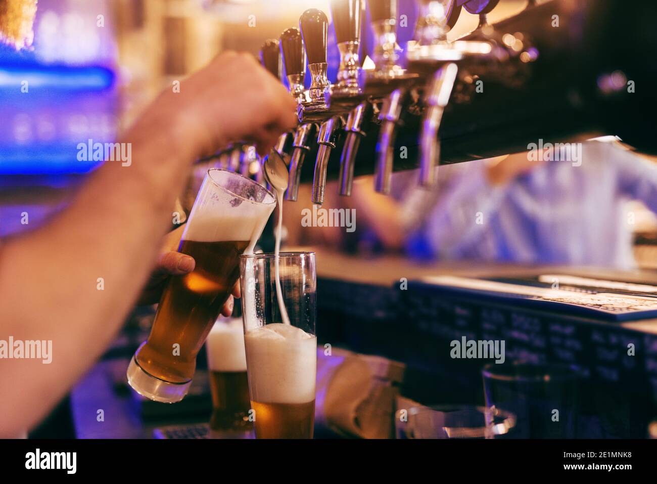 Close up of bartender pouring beer into glass. Pub interior Stock Photo ...